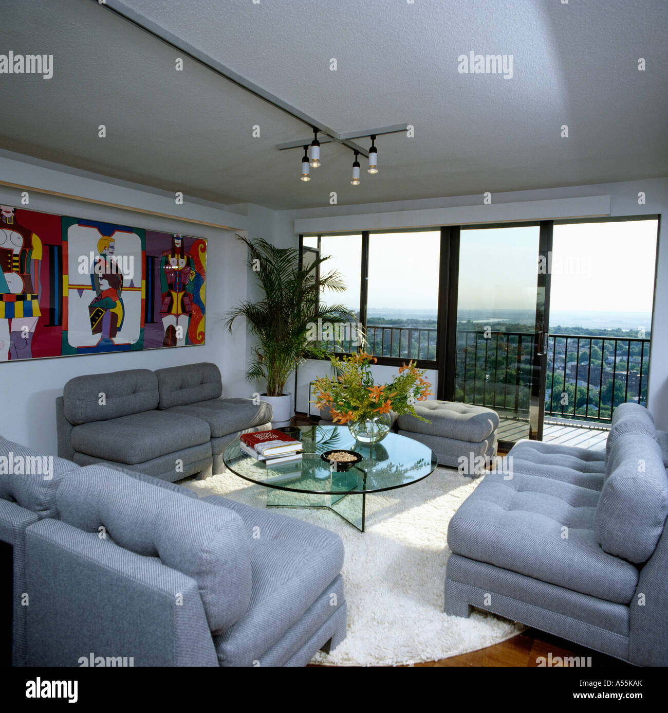 Eighties sittingroom with grey sofas and large windows with view of ...