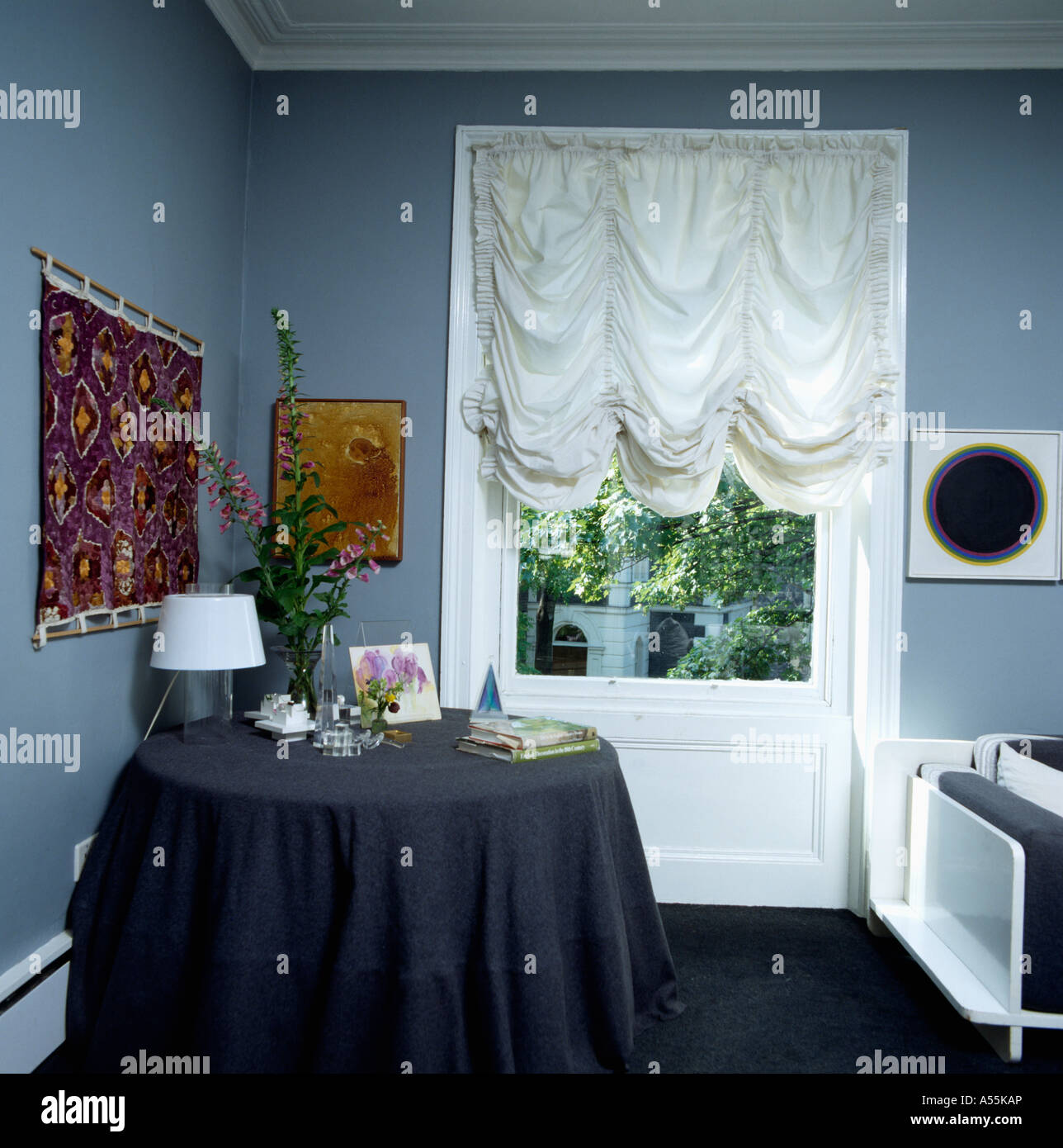 Corner of blue eighties sittingroom with white festoon blind and window ...