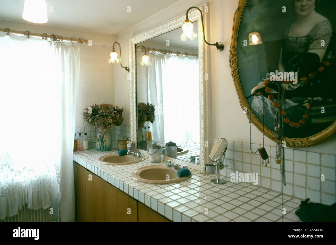 Mirror above double basins in tiled vanity unit in white bathroom Stock ...