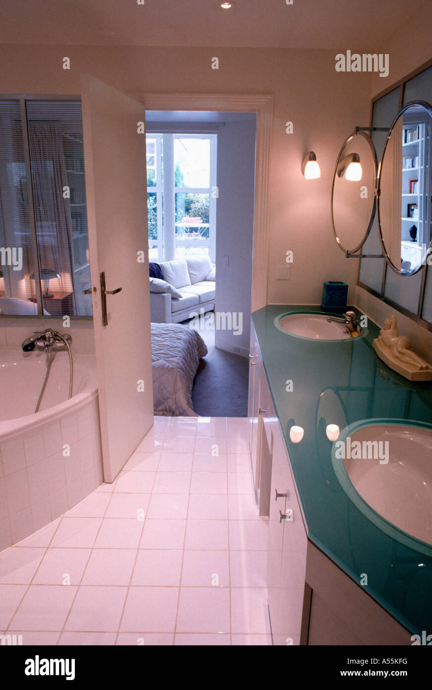 Double basin in glass vanity unit in modern ensuite bathroom with white ...