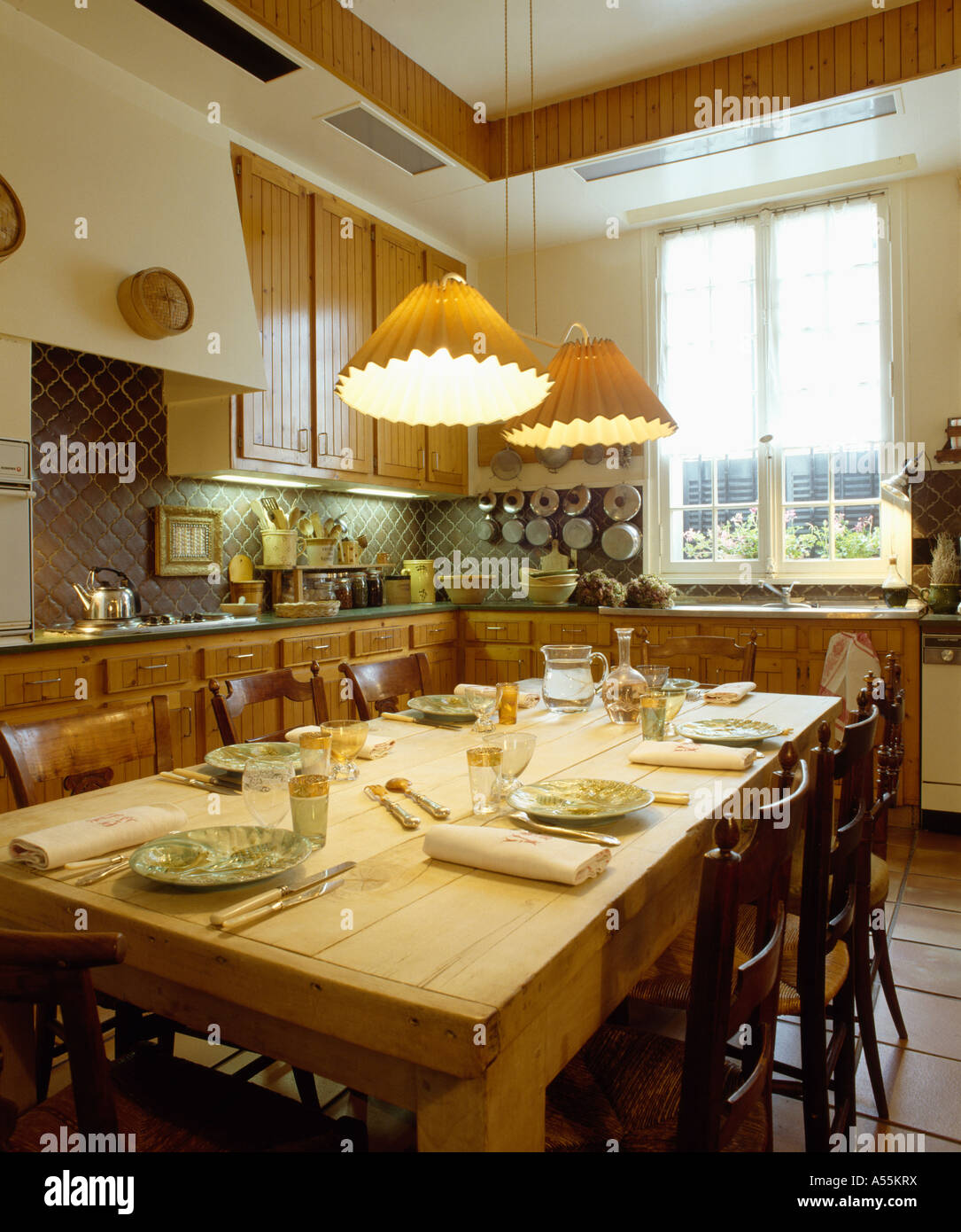 Double pendant lamps above table with place settings in traditional ...