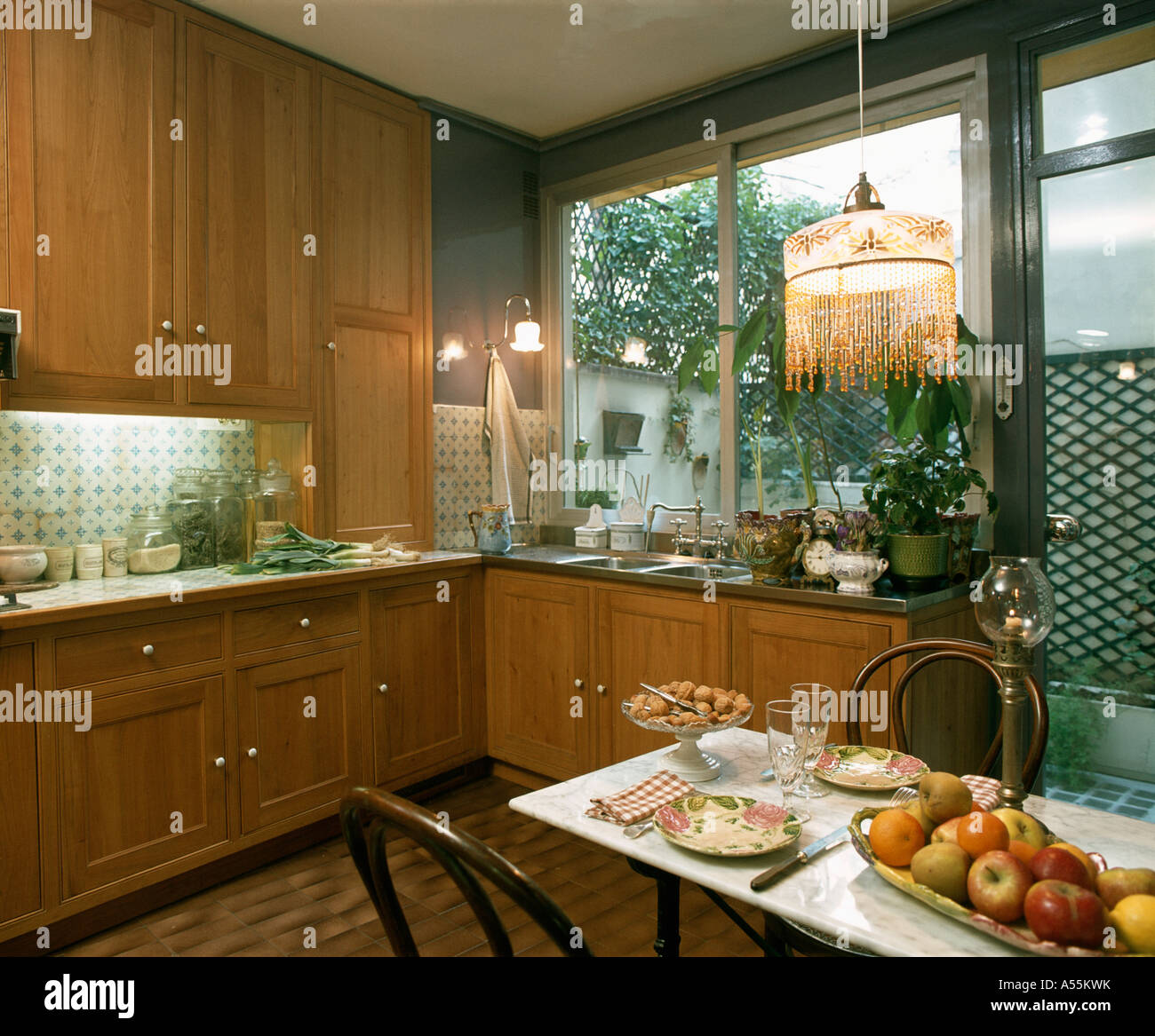 Beaded lampshade above table with place settings in kitchen with wooden ...