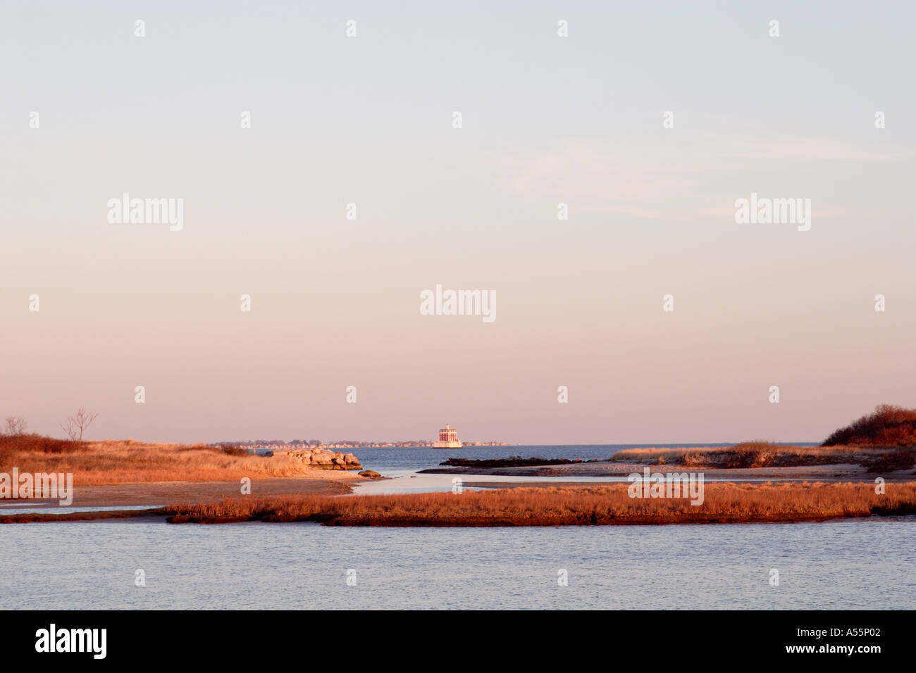 Light house in bay at sun set Stock Photo - Alamy