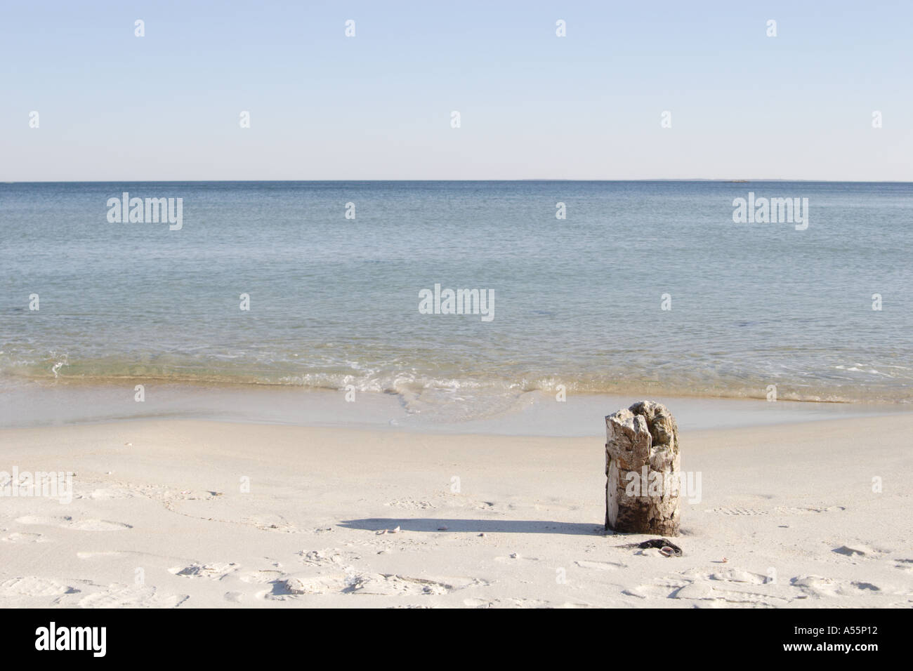 Old wooden post buried in sand on beach Stock Photo - Alamy