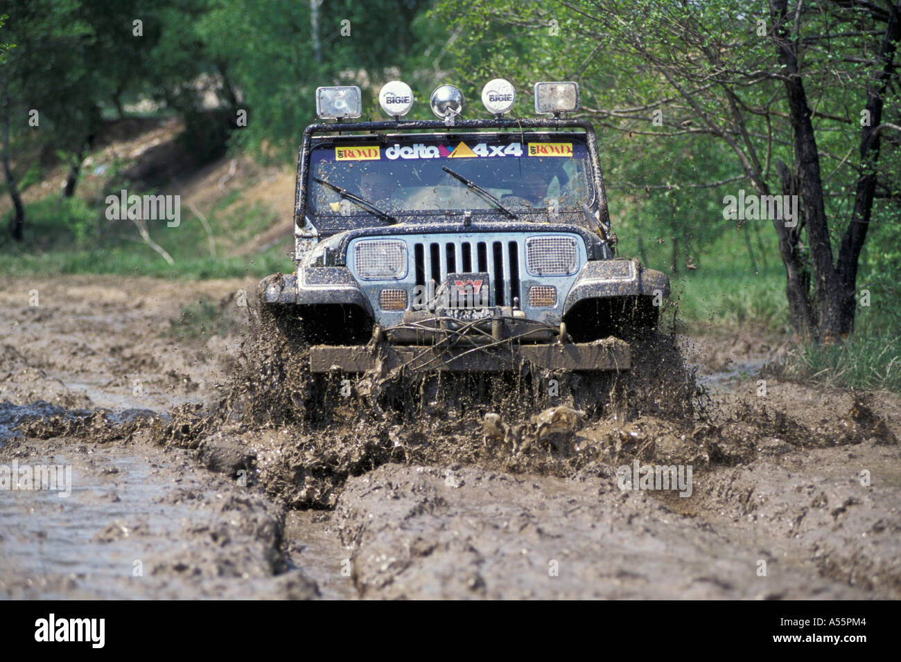 Jeep offroad vehicle are driving with speed through mud Stock Photo - Alamy