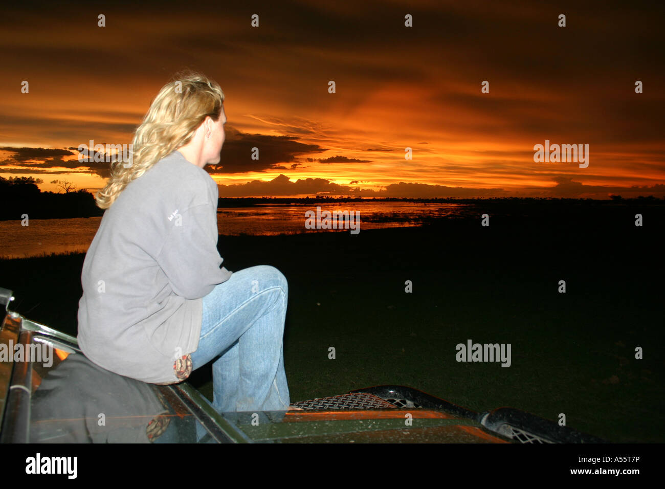 Girl on car bonnet Stock Photo - Alamy