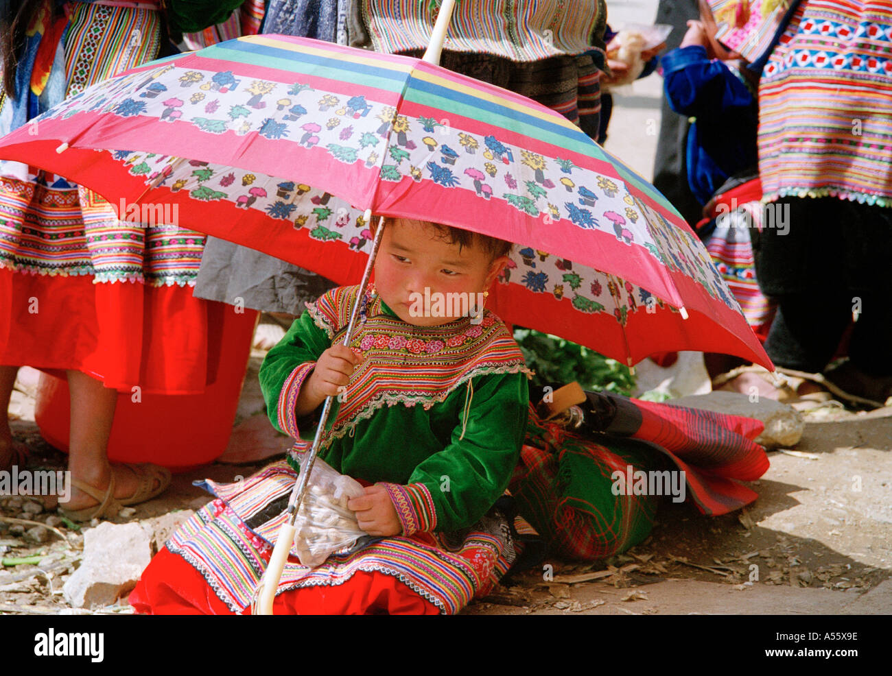 An Hmong child shelters from the sun under an umbrella in BacHa ...