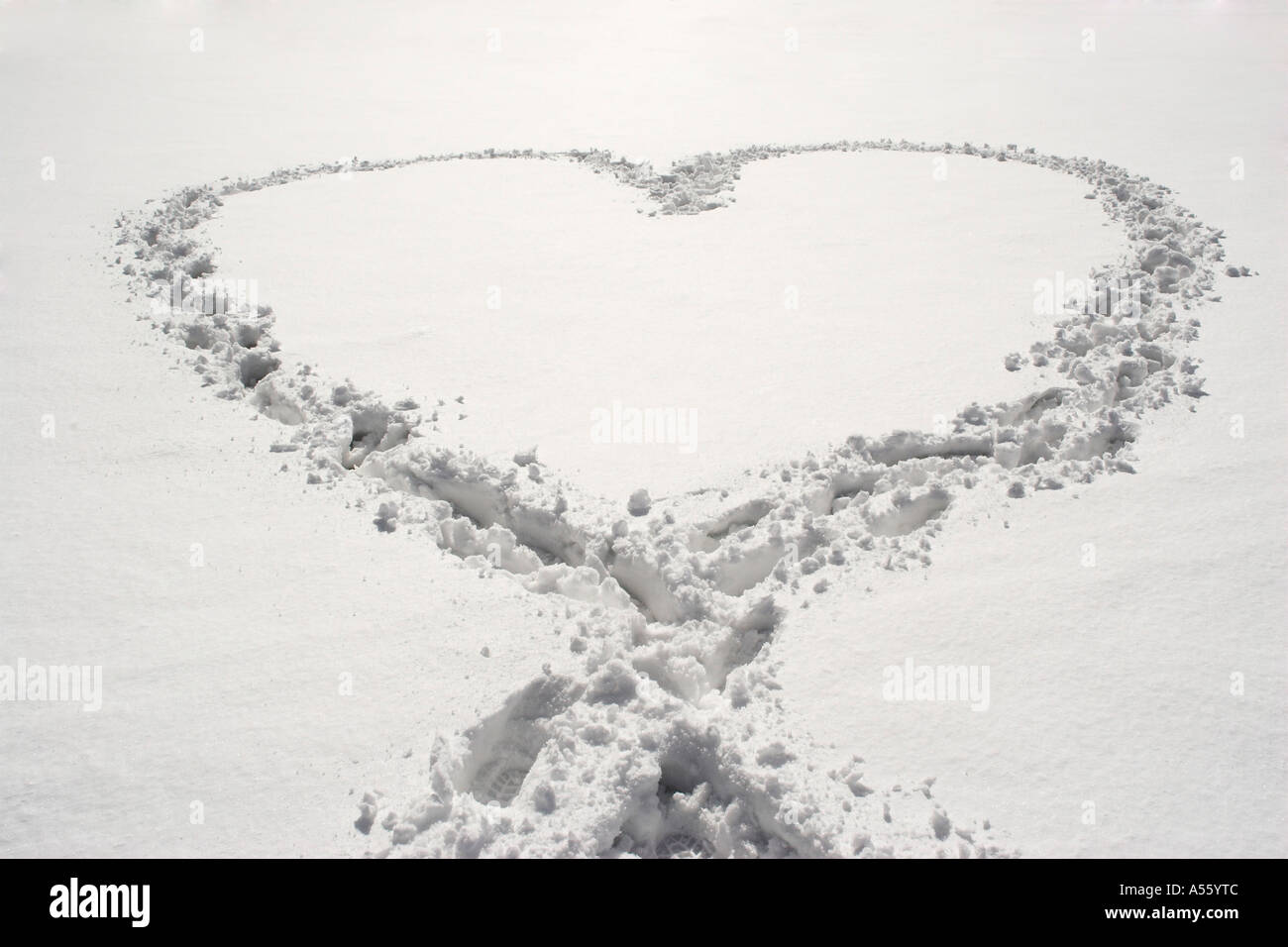 Footprints in the snow forming a heart shape Stock Photo - Alamy
