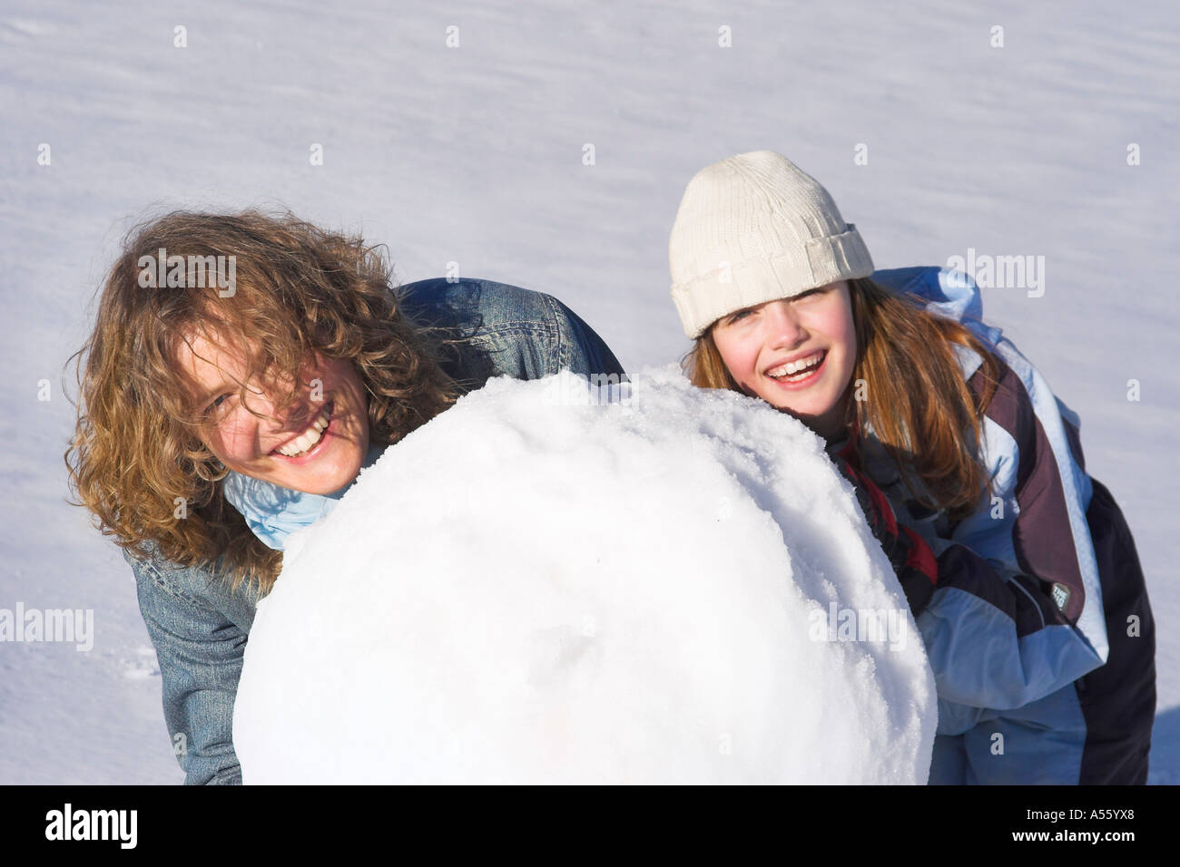 MR Mother and daughter build a snowman Stock Photo - Alamy