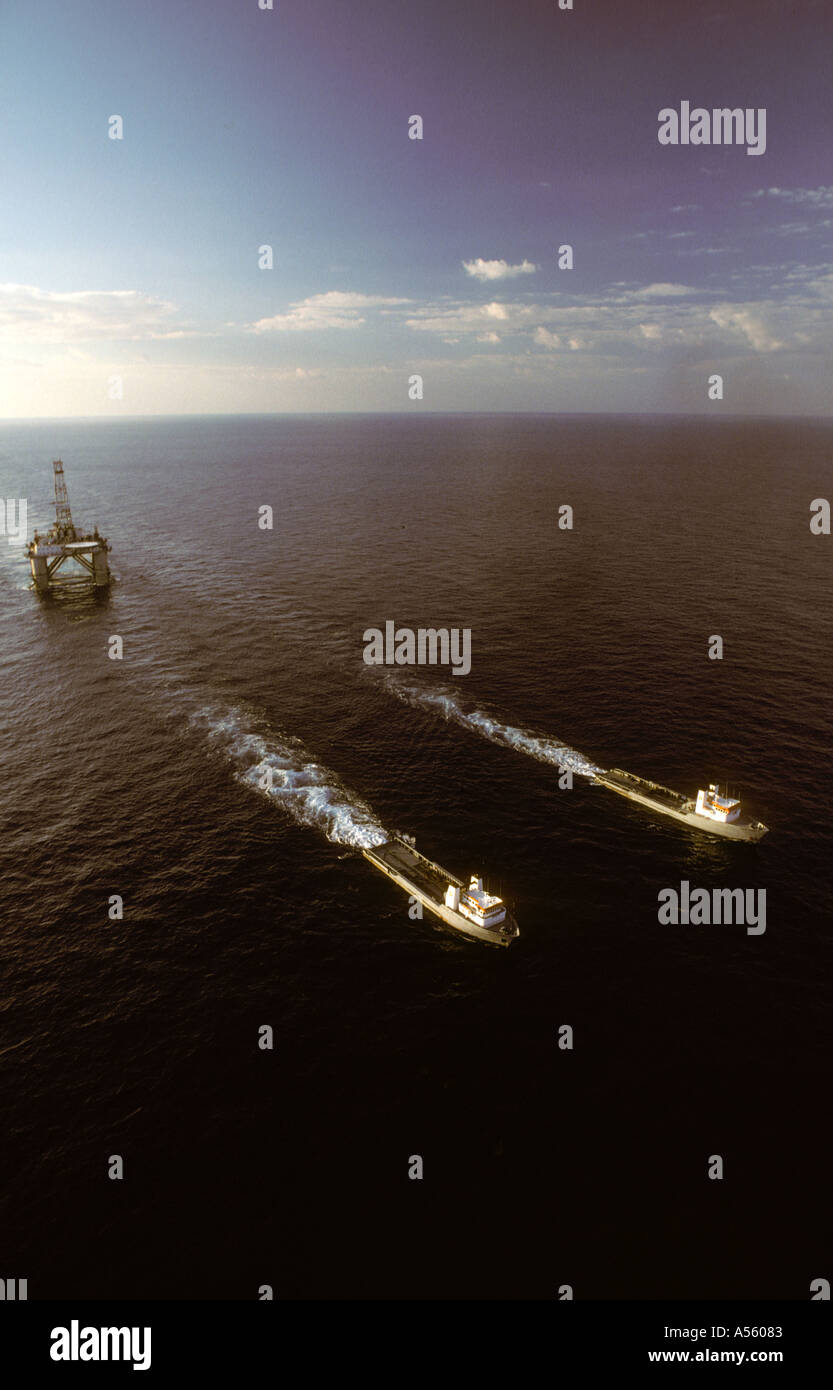 aeria view of semi submersible off shore oil rig being towed by two tug ...