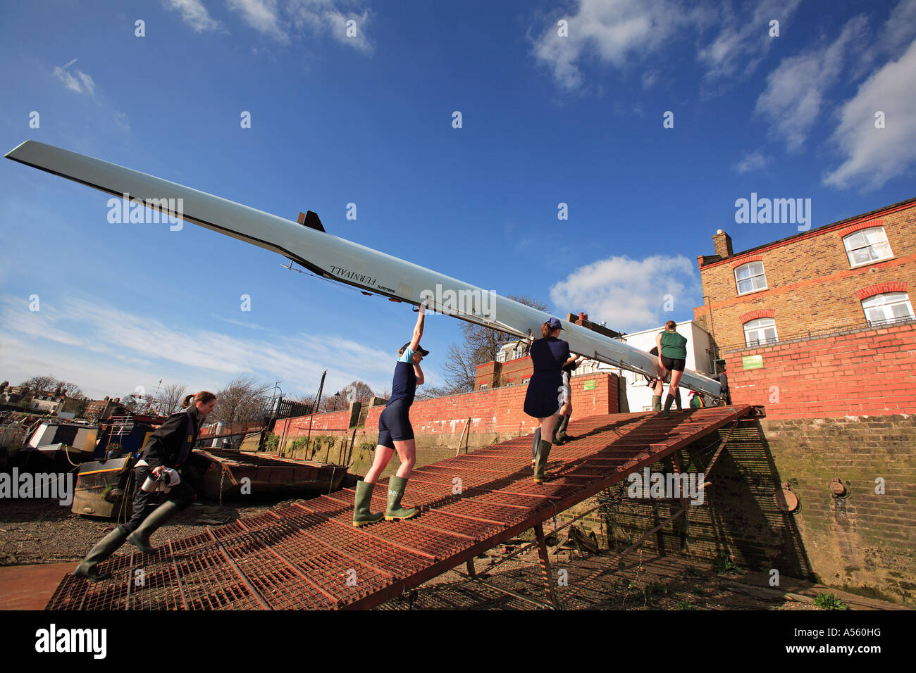 united kingdom west london a rowing boat being carried into a boathouse ...