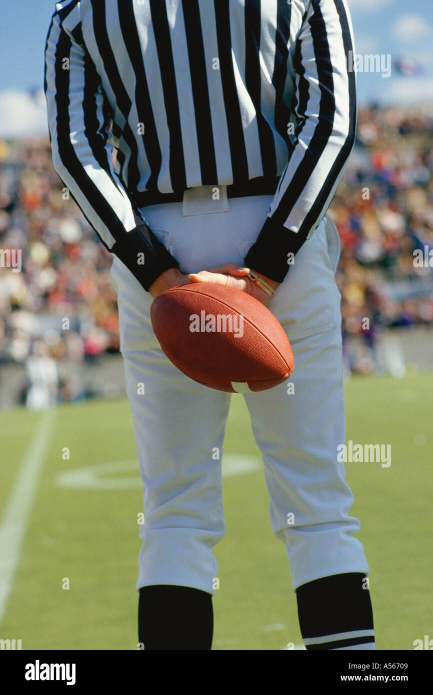 Referee holding football behind back Stock Photo - Alamy