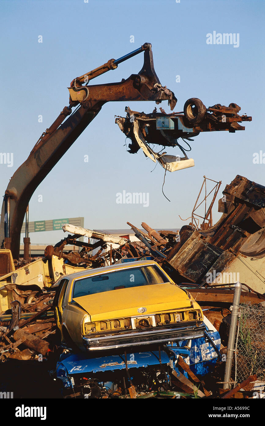 Heavy machinery dropping car in junkyard Stock Photo - Alamy