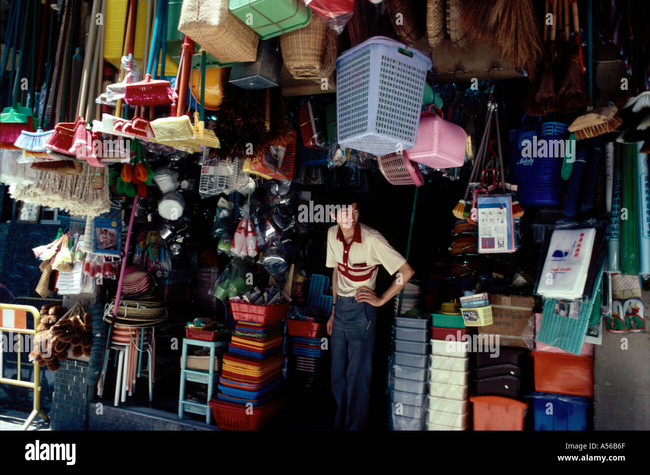 A small hardware shop in Hong Kong the shopkeeper stands in the doorway ...