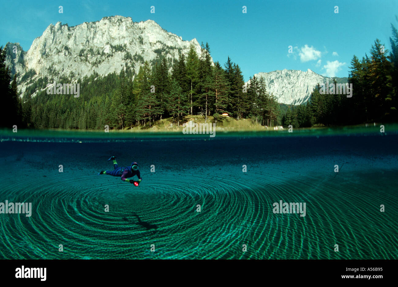 split level picture of a skindiver in an cristal clear mountain lake ...