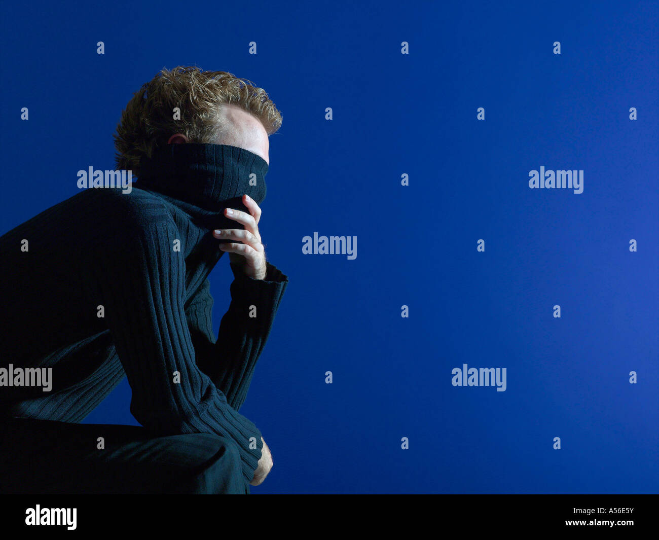 Young man with hidden face, side view Stock Photo - Alamy
