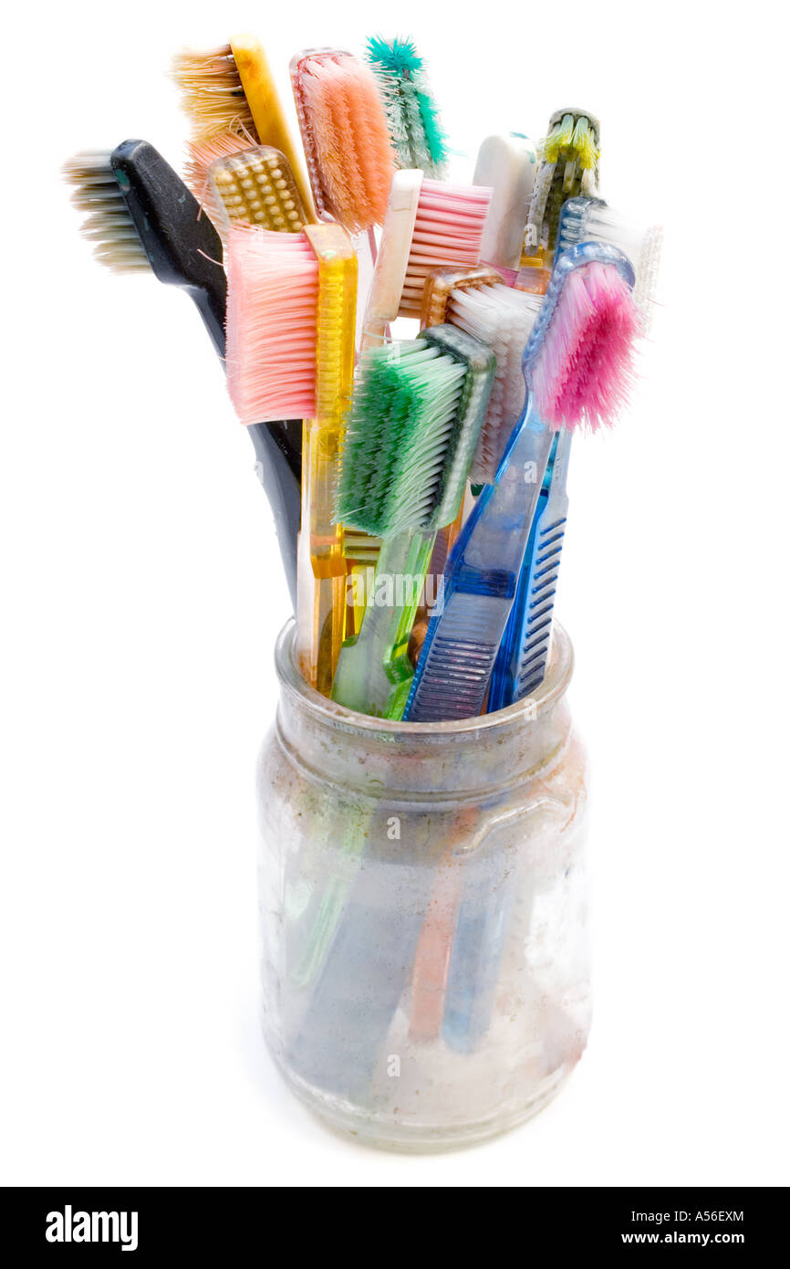 Old toothbrushes in a mug used for creative artwork. Isolated on white ...