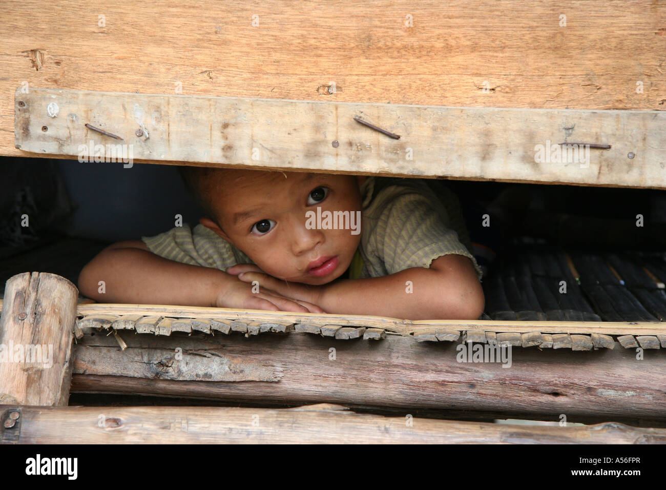Painet iy8469 thailand child kid boy dweller slum chiang mai peeping out under door home photo ...