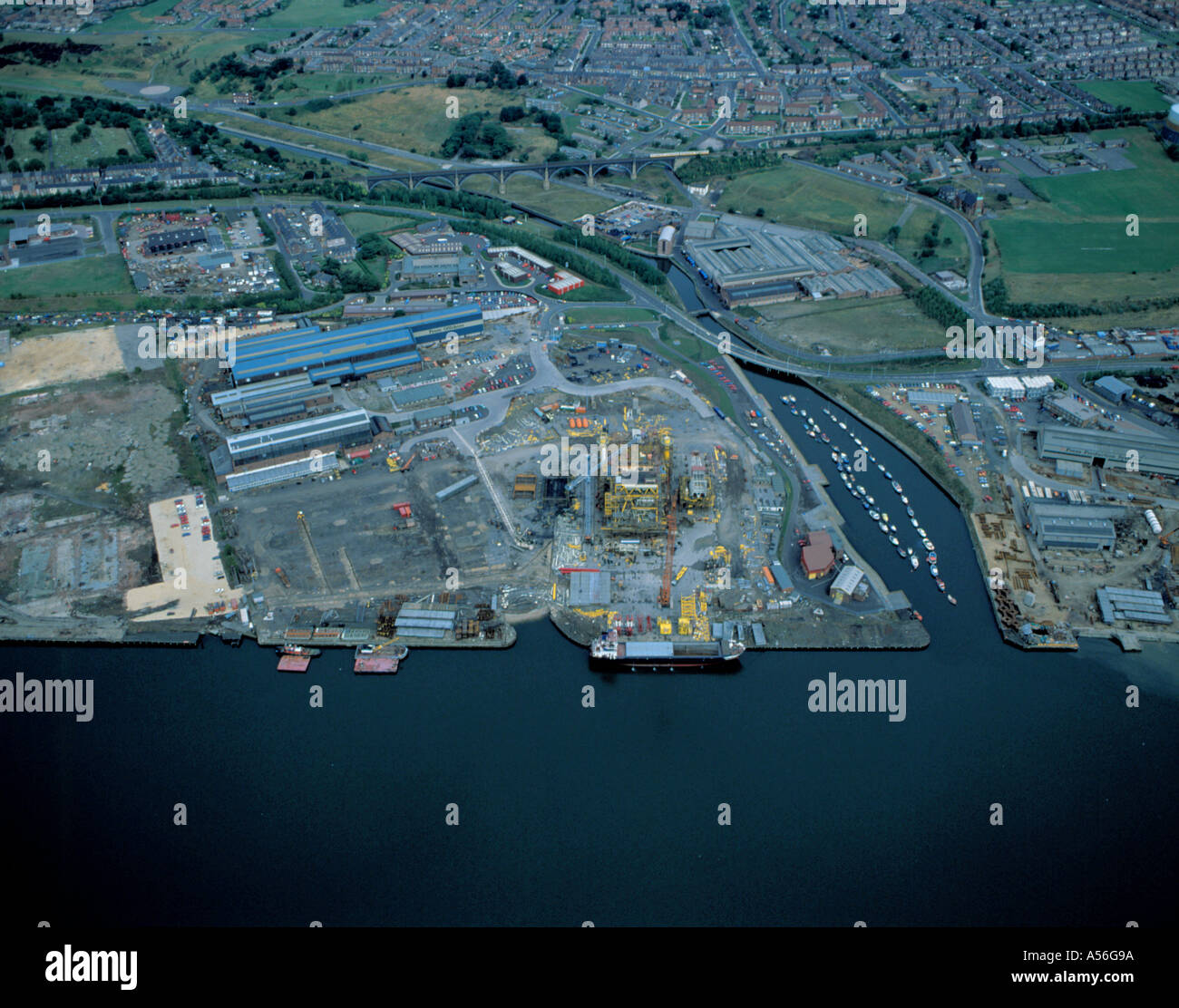 Aerial view of offshore industry fabrication yard, with housing estates ...