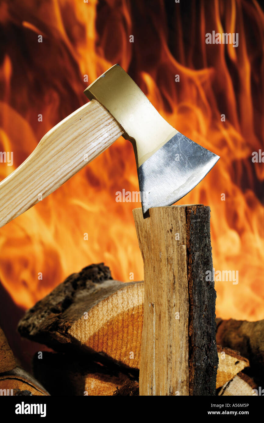 Axe and firewood, fire in background Stock Photo - Alamy