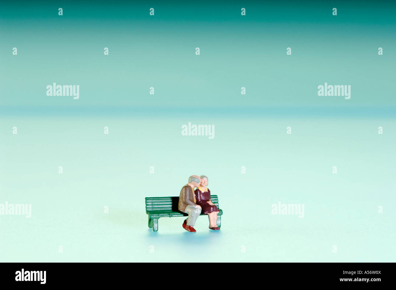 Figurines of couple sitting on bench Stock Photo - Alamy
