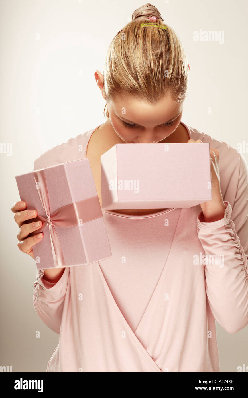 Young woman looking into gift box Stock Photo - Alamy
