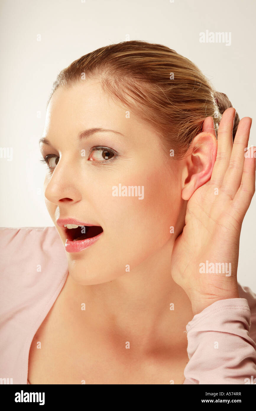 Young woman cupping hands to year, close-up, portrait Stock Photo - Alamy