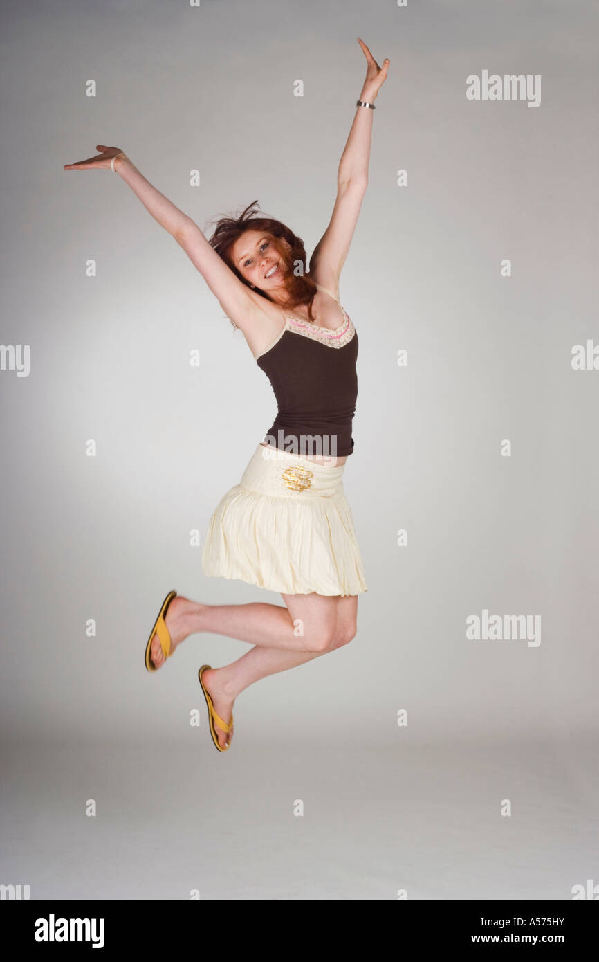 Young woman jumping arms up Stock Photo - Alamy
