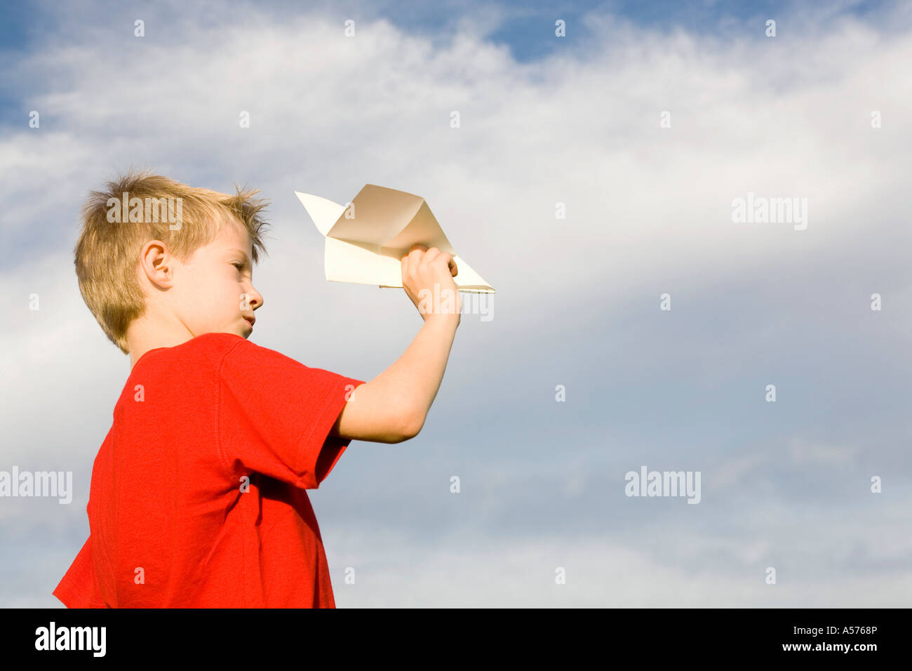 Boy (10-12) holding paper plane, side view Stock Photo - Alamy