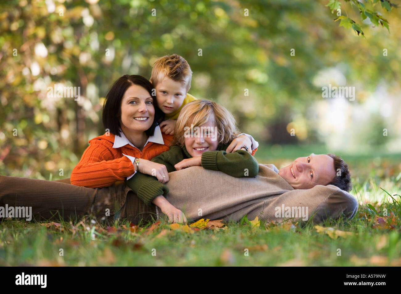 Parents with two sons lying in meadow Stock Photo - Alamy
