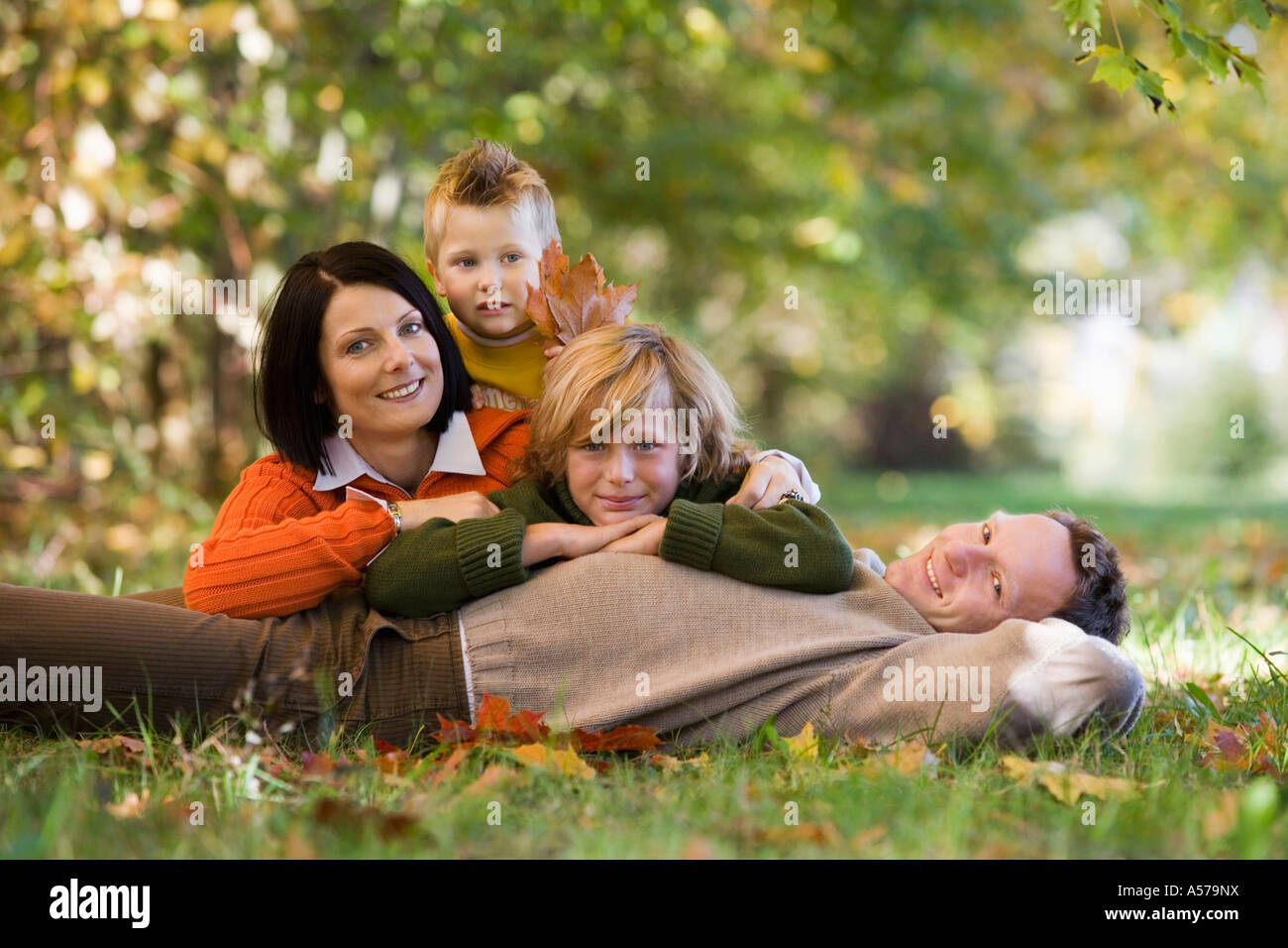 Parents with two children (6-11) lying in meadow, smiling Stock Photo ...
