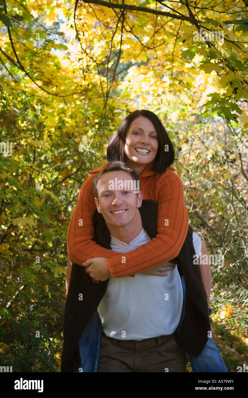 Man carrying woman piggyback, smiling, portrait Stock Photo - Alamy