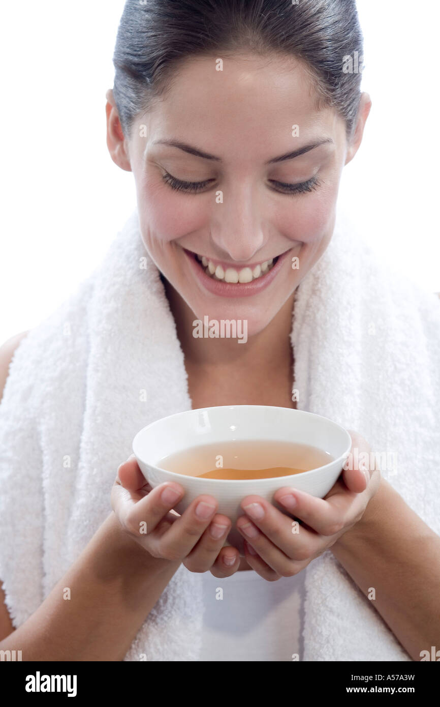 Young woman holding tea bowl, smiling, close-up Stock Photo - Alamy