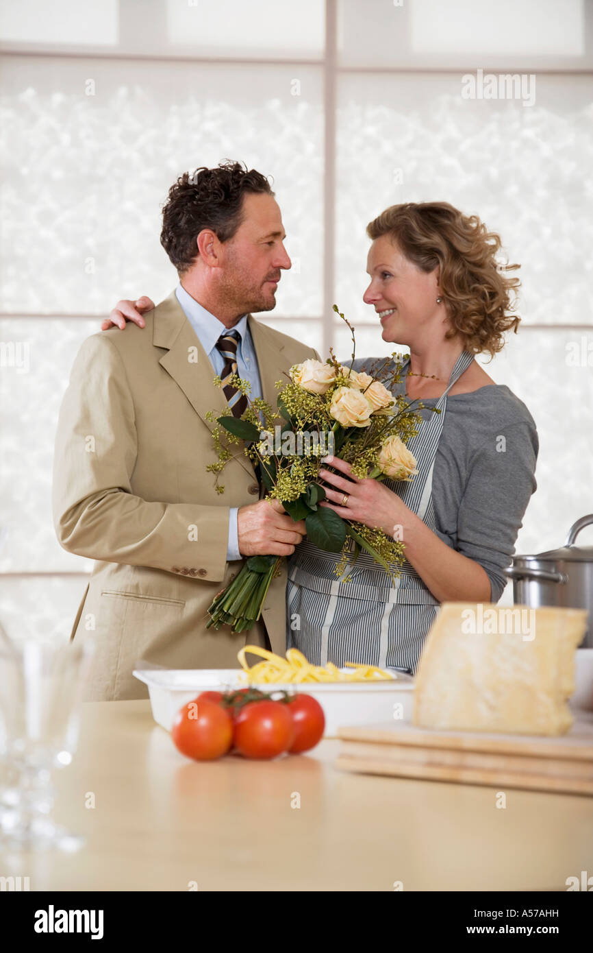 Mature couple in kitchen with flower bouquet Stock Photo - Alamy