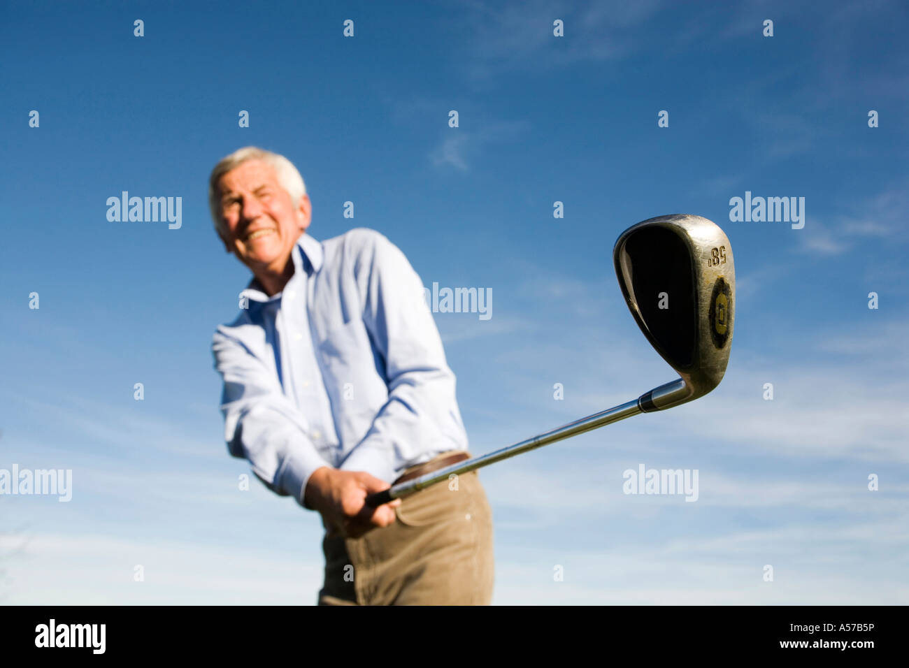 Senior adult man holding golf club Stock Photo - Alamy