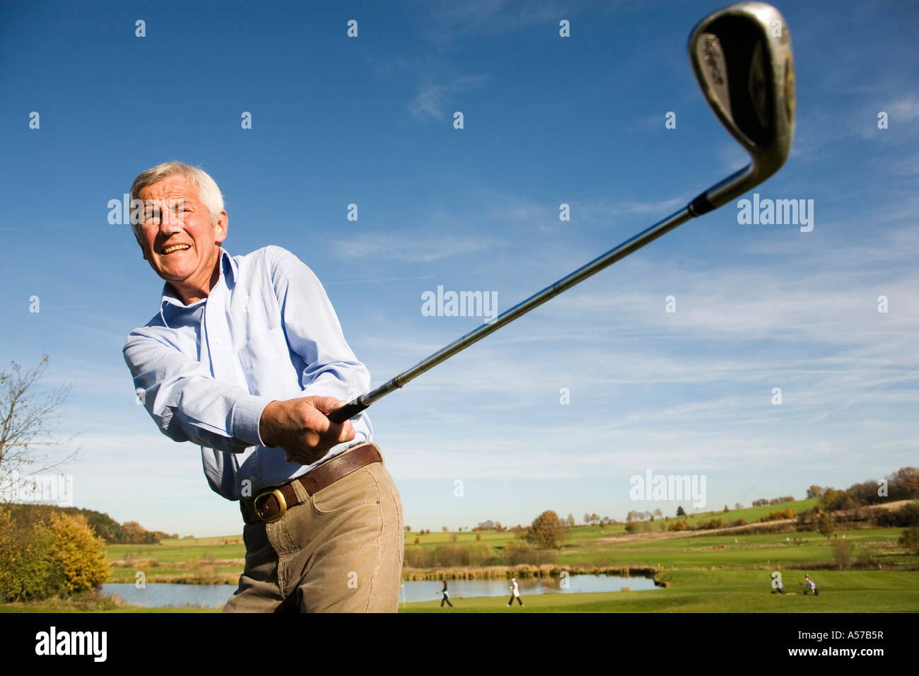 Senior adult man holding golf club Stock Photo - Alamy