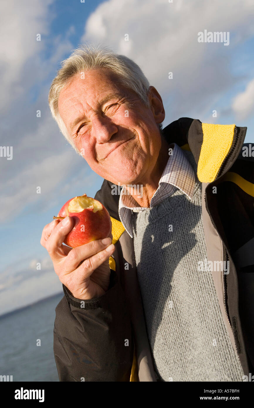 Senior adult man eating apple Stock Photo - Alamy