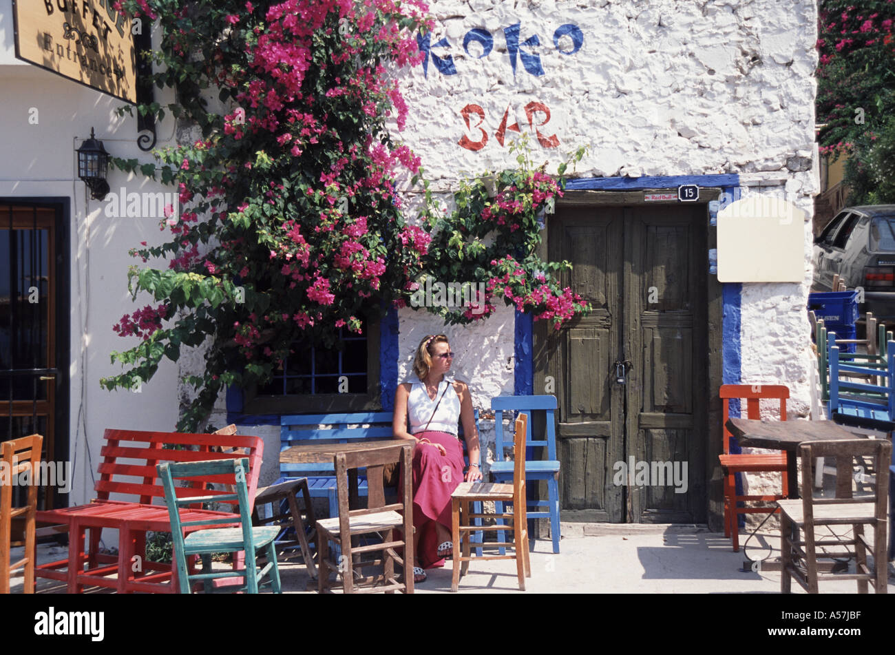KALKAN, TURKEY. A young woman sitting outside a bar on the seafront in ...