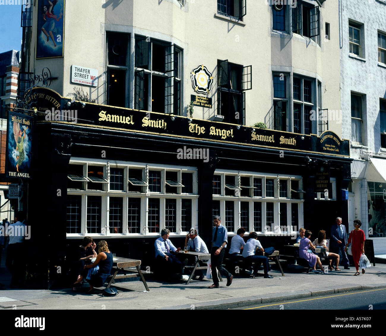 English pub scene The Angel Thayer St London people sitting on pavement ...