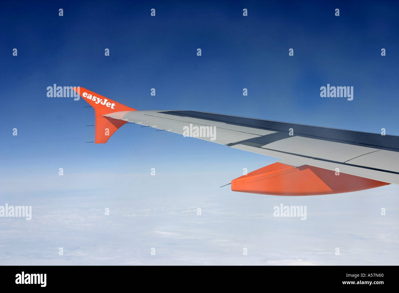 Aerial view of Easyjet aircraft wing and wingtip with sky and clouds ...