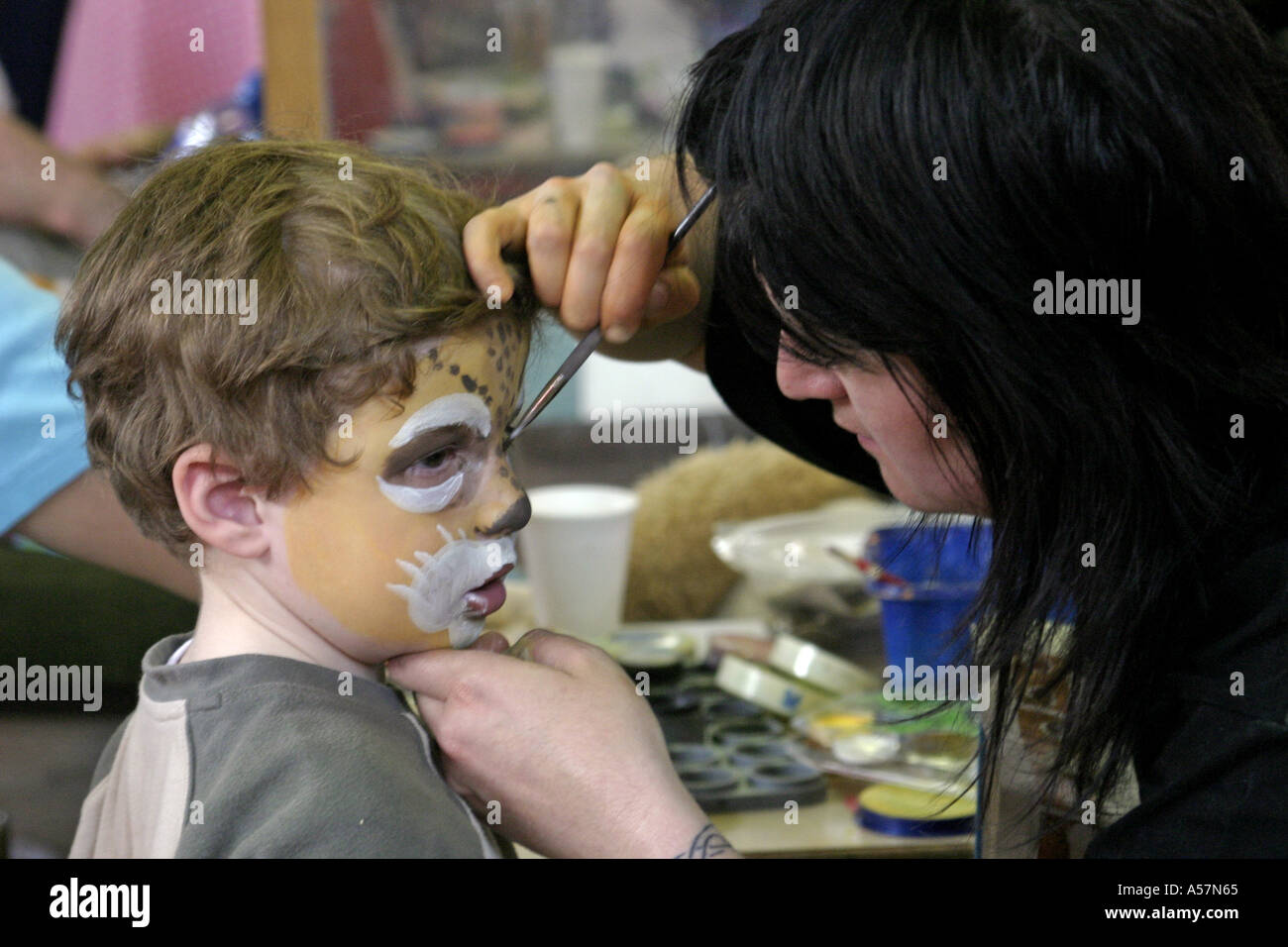 Young boy having his face painted by a face painter Stock Photo - Alamy