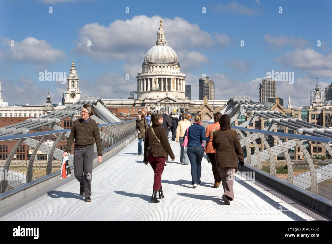 Pedestrians crossing the Millenium Bridge London England with St Pauls ...