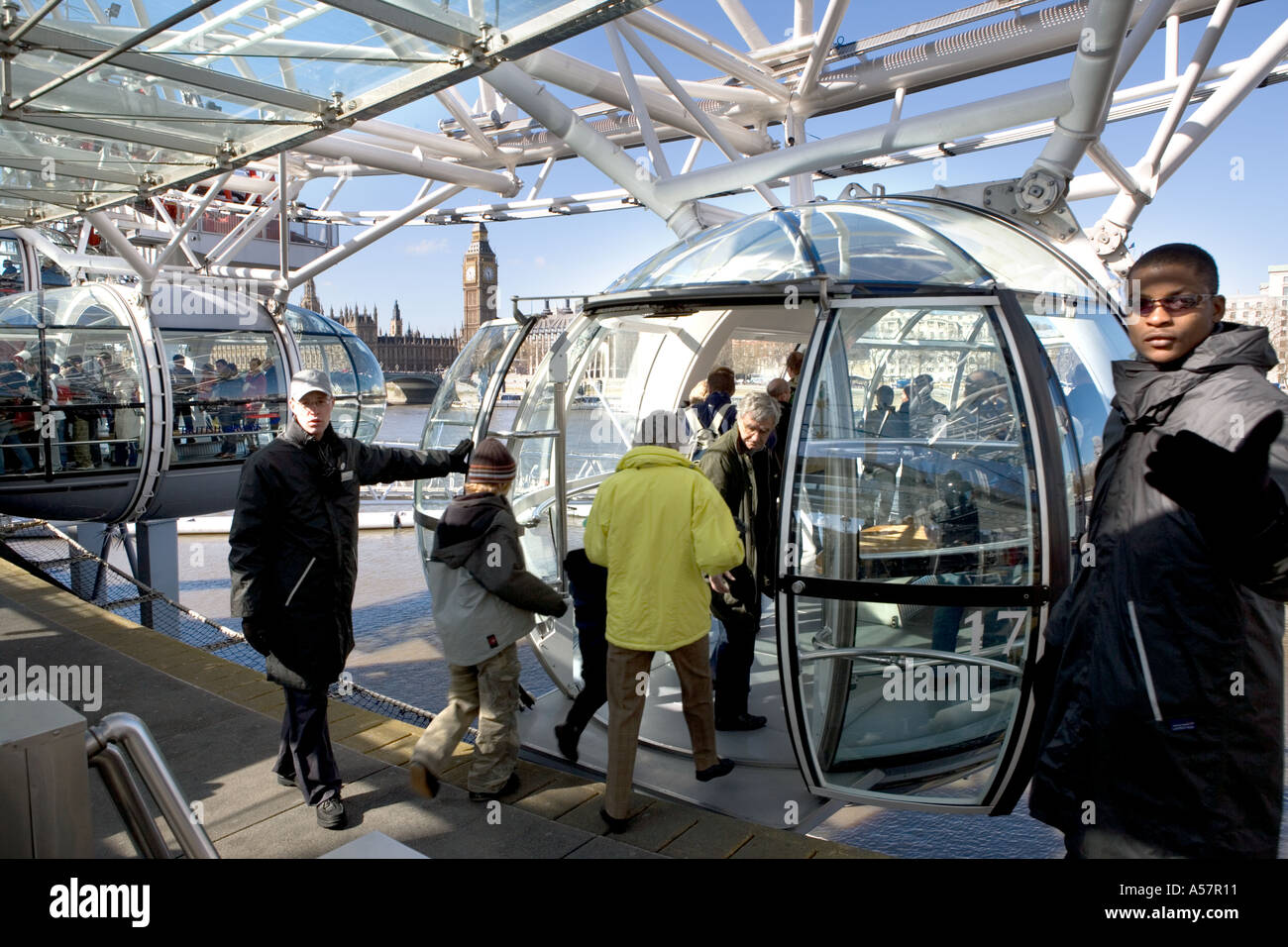 Staff help people board a pod on the London Eye London England Stock ...