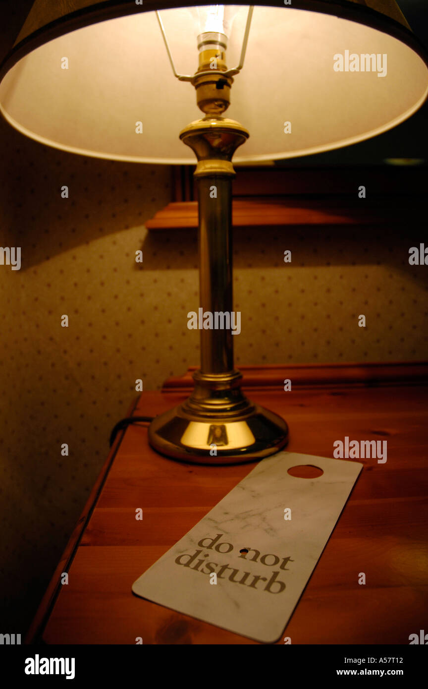 Do not disturb label on a bedside table with lamp in a hotel room Stock ...
