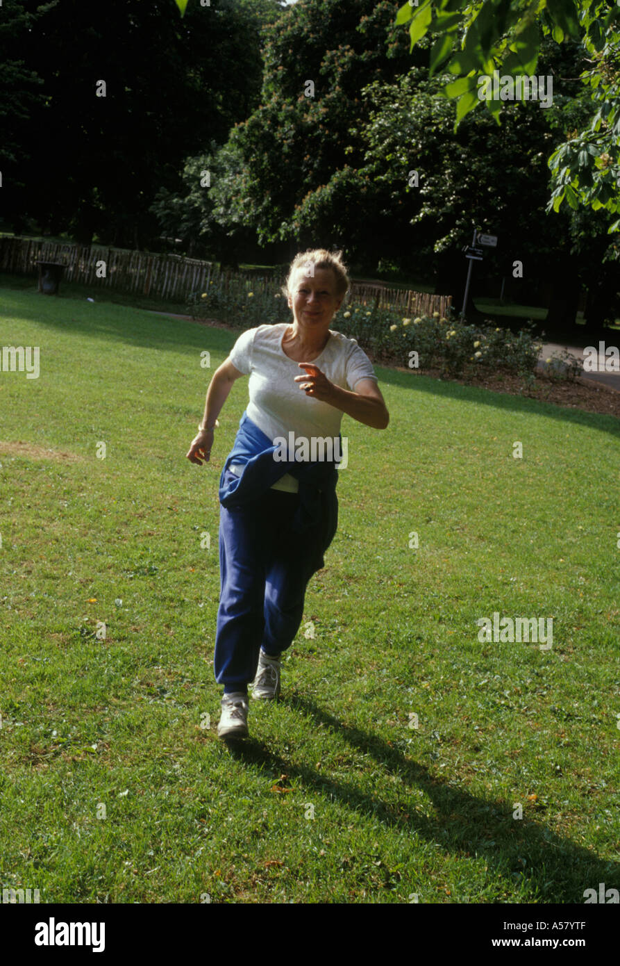 older woman jogging in park Stock Photo - Alamy