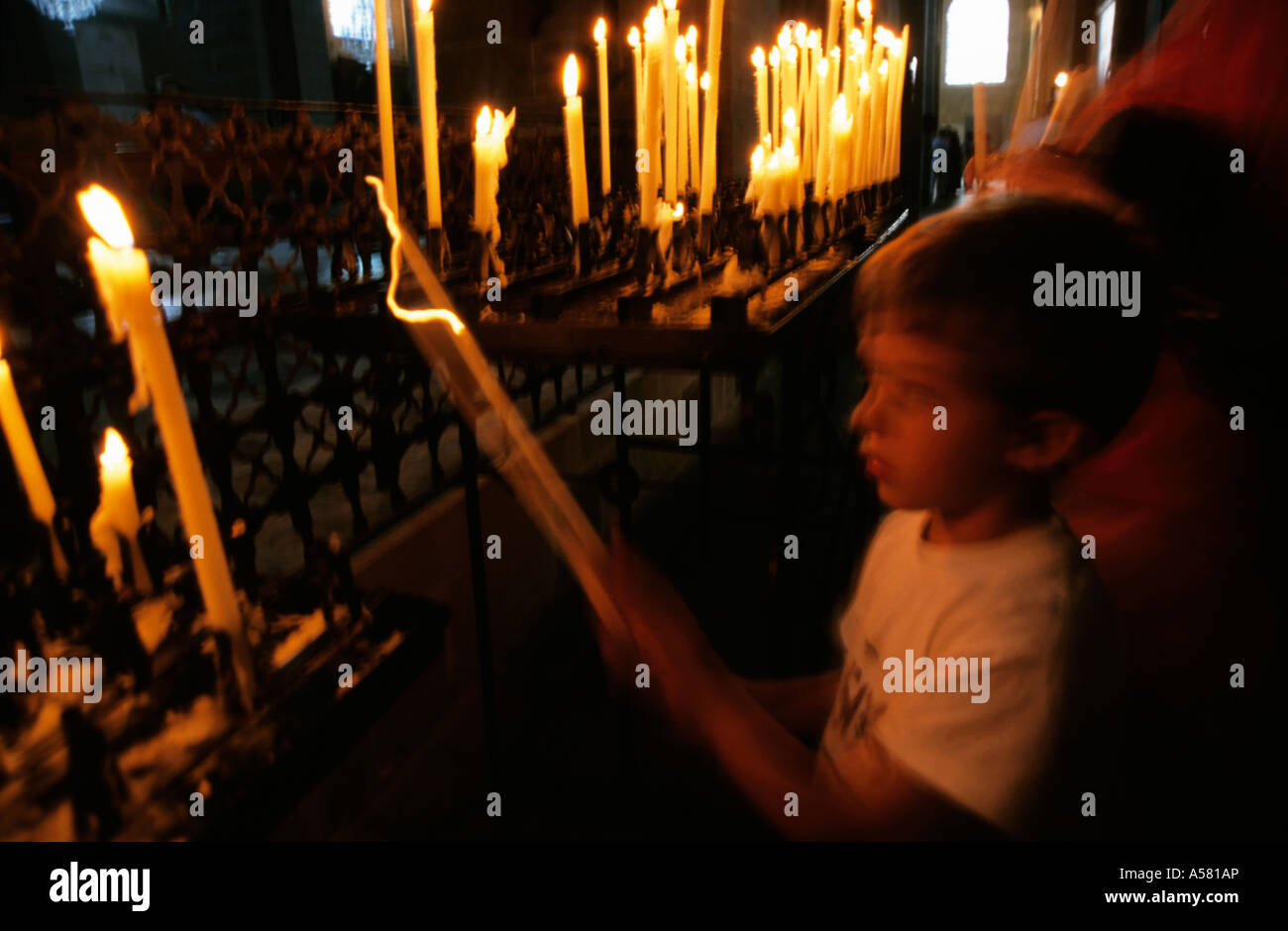 Children lighting candles inside a church, France Stock Photo - Alamy