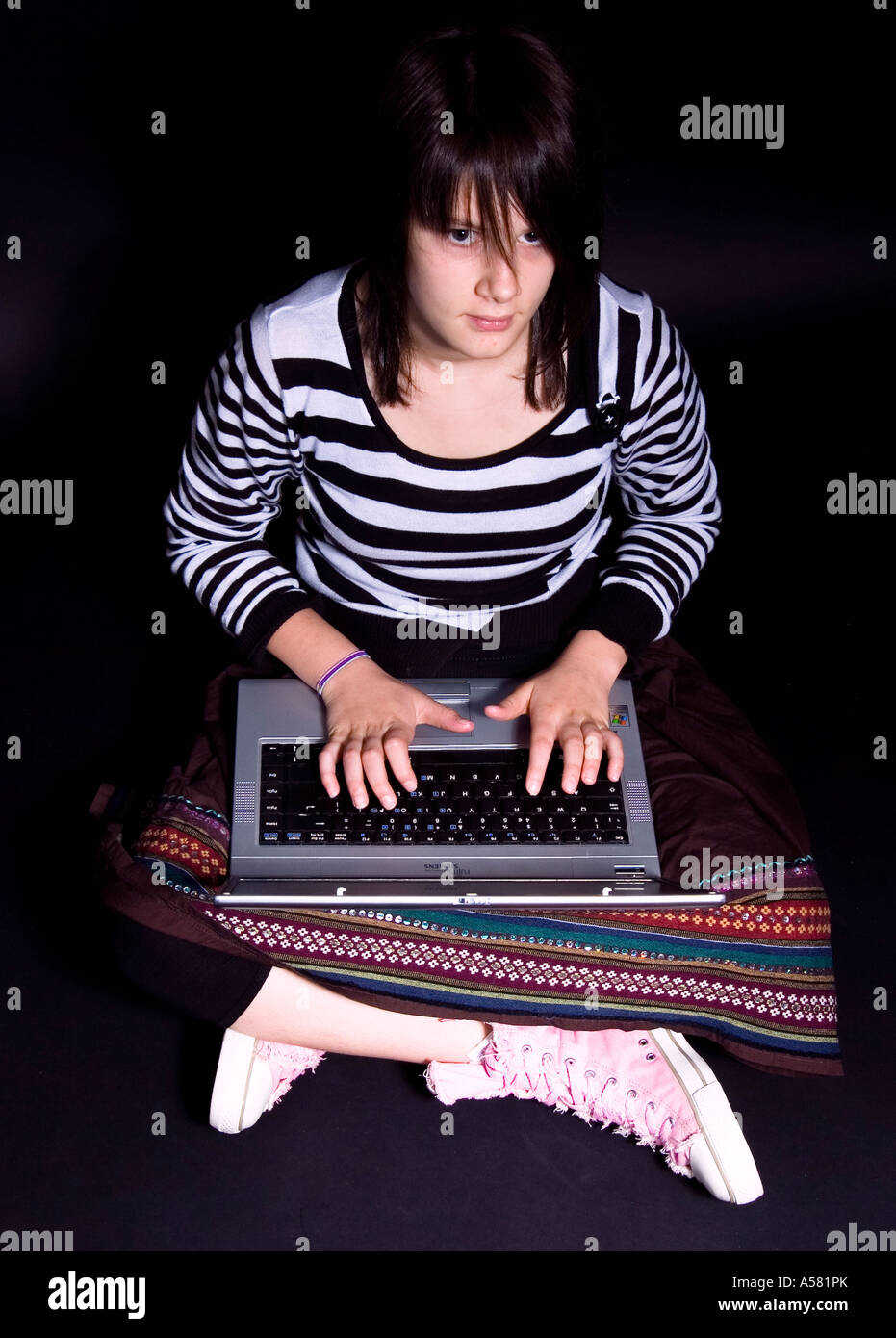 Young girl posing on a laptop computer whist sitting down Stock Photo ...