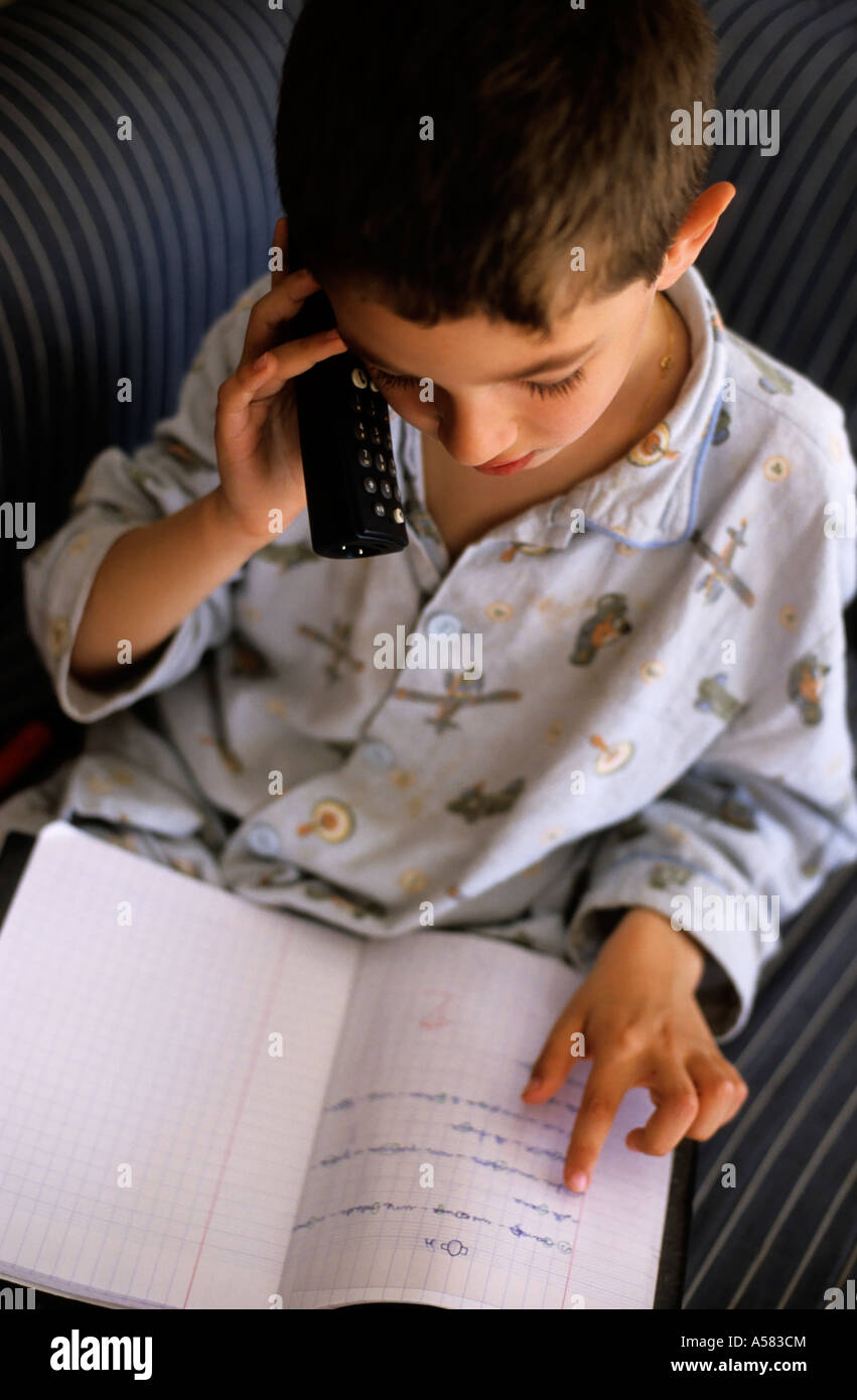 Young boy discussing his homework with a friend on the phone Stock ...