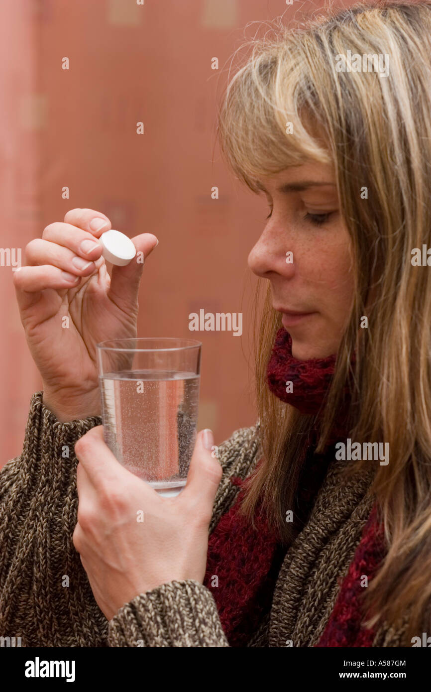 Woman taking tablet Stock Photo - Alamy
