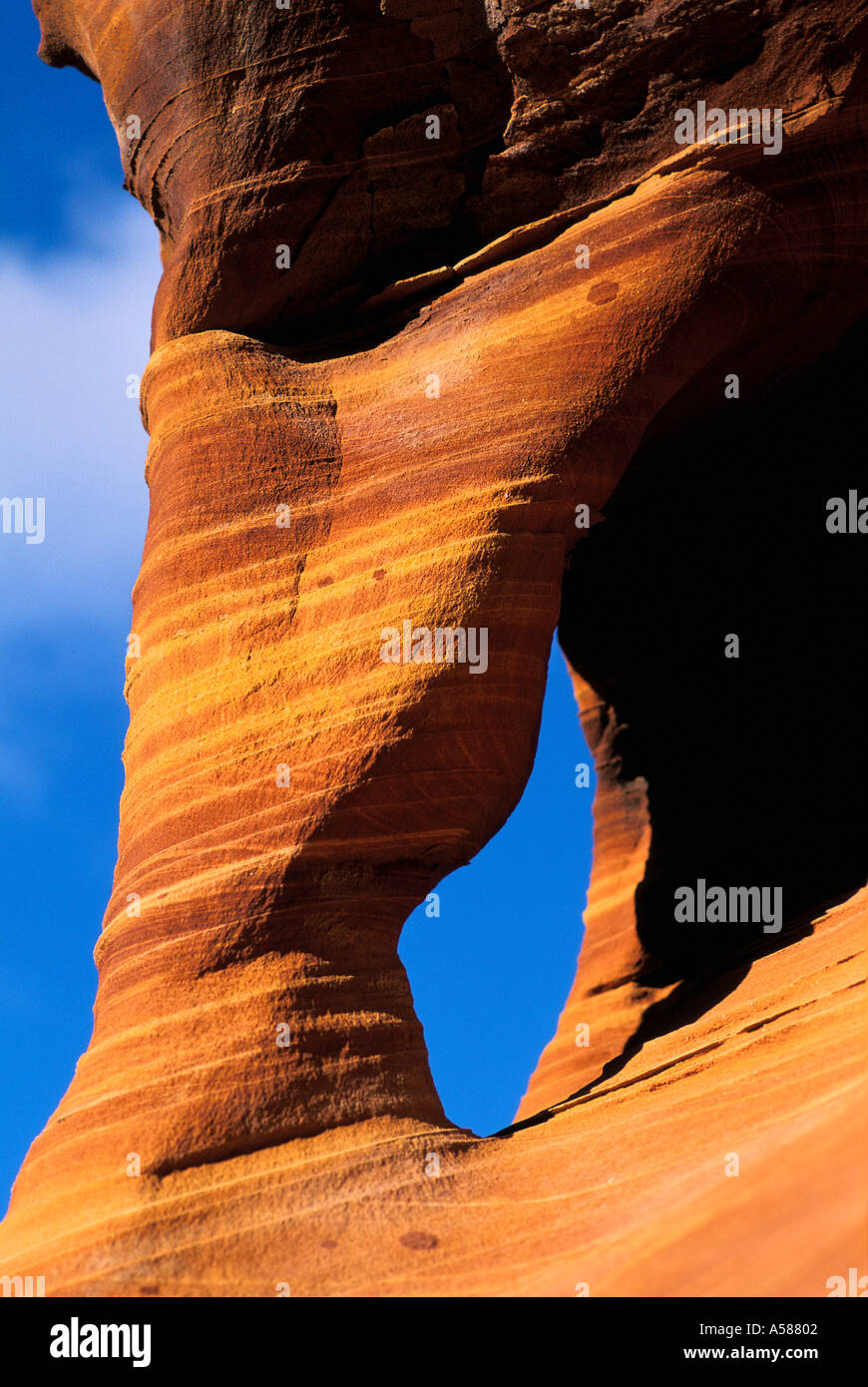 Natural arch in colorful orange and tan banded sandstone Pariah Plateau ...